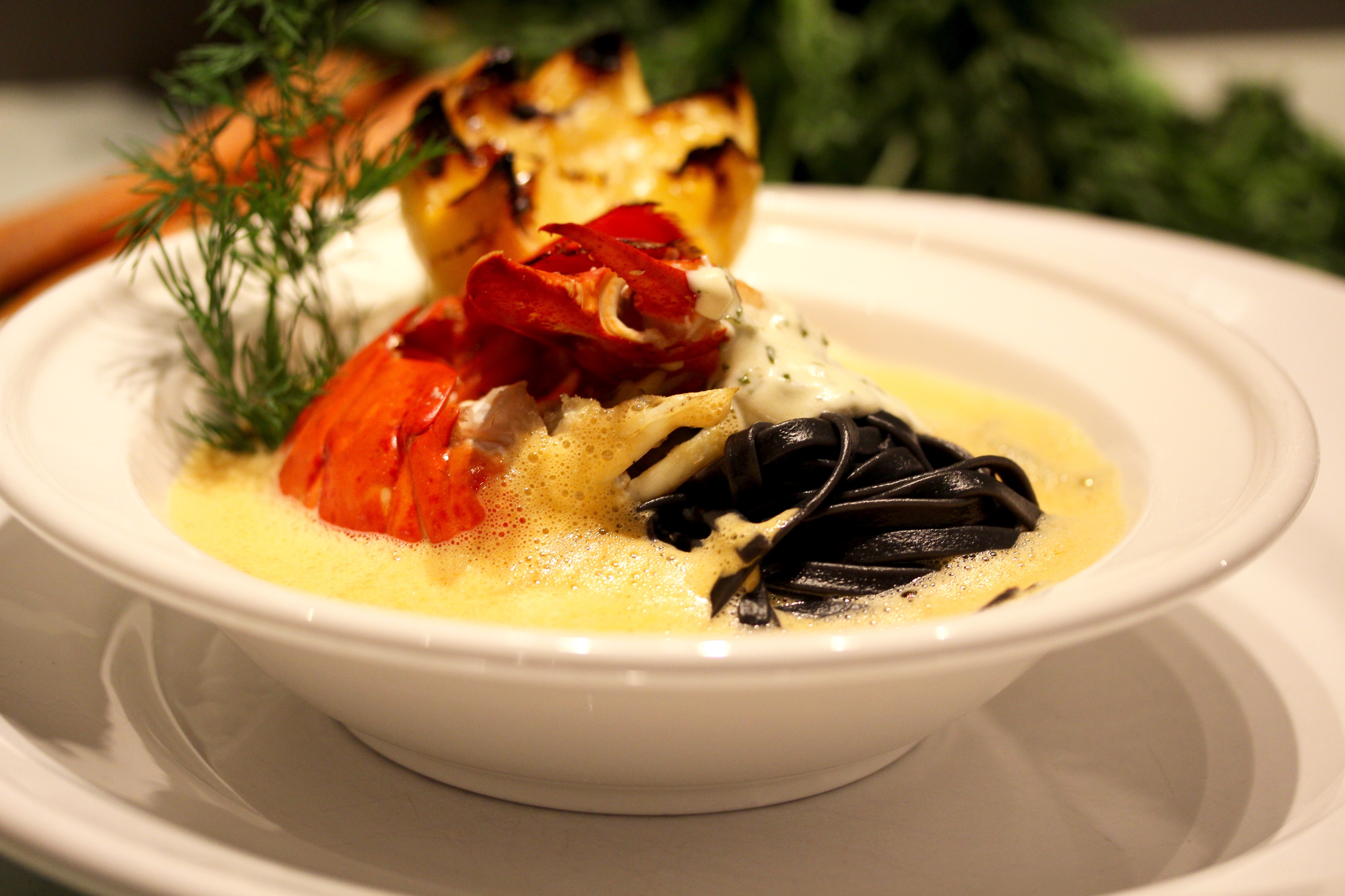 Krassekrämstoppad grillad hummer med bläckfisklinguine i champagneskum